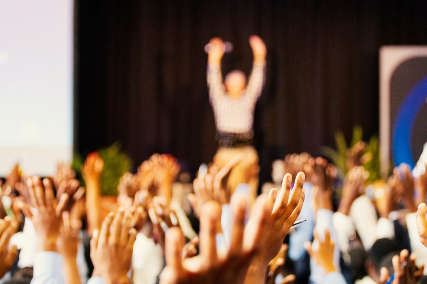 Large group raising hands – Find A Facilitator